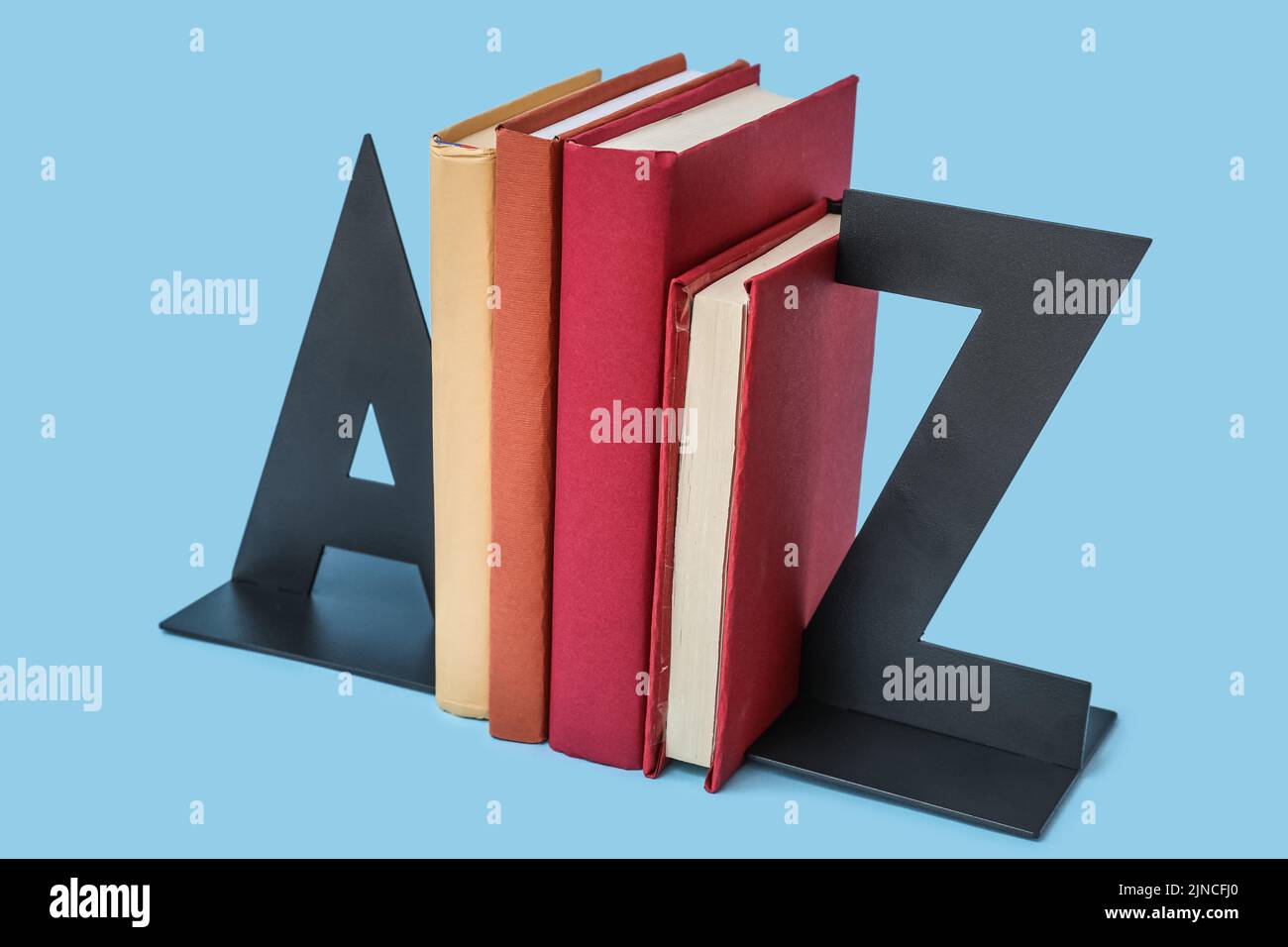 Stylish stand with books on blue background Stock Photo - Alamy