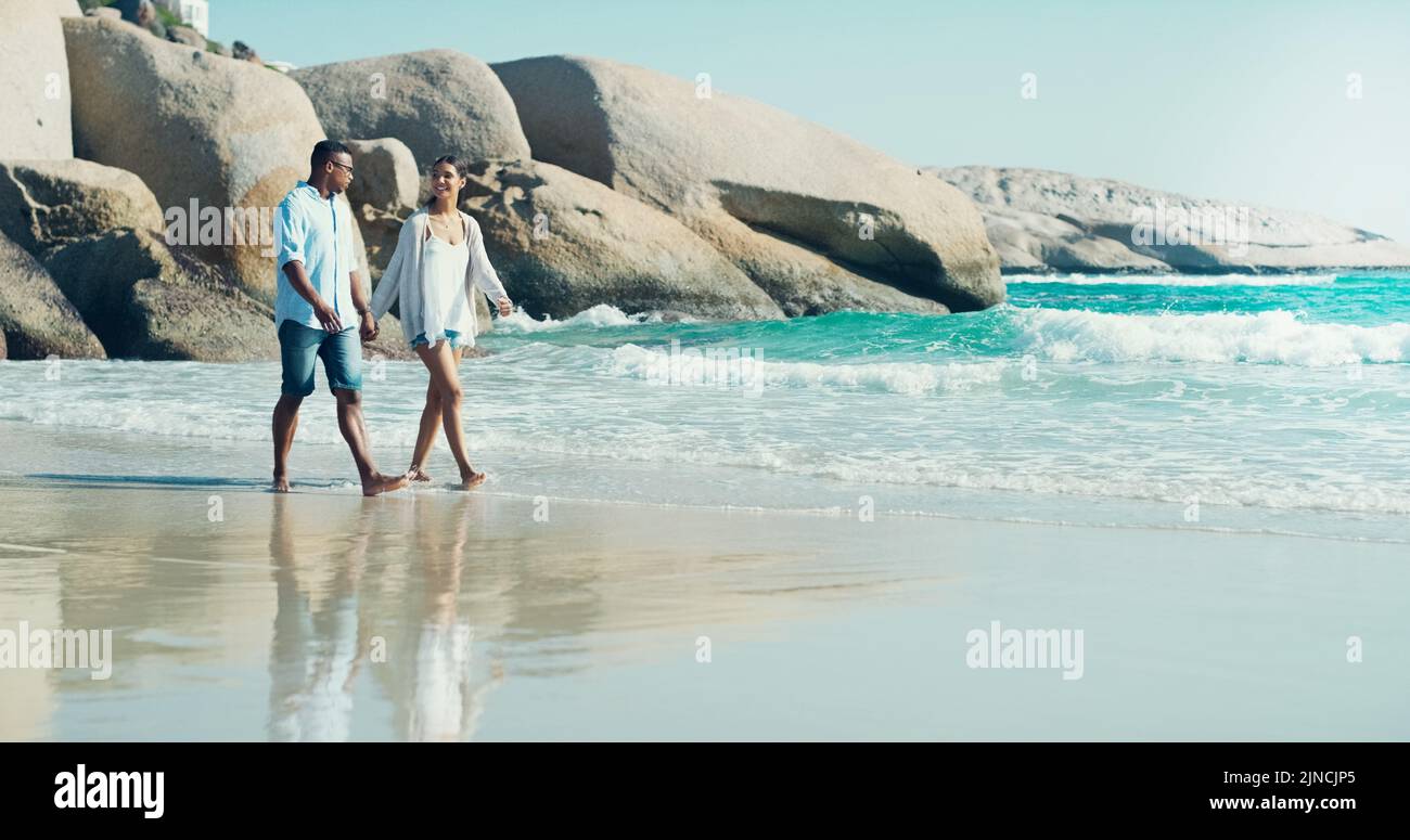The beach was made for sweethearts. Full length shot of a happy young couple taking a walk by ...
