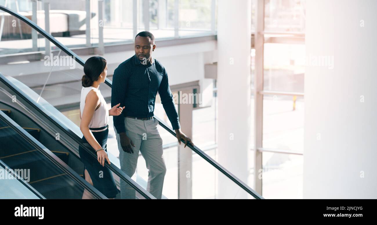 Keeping the discussion moving. two young businesspeople having a chat ...