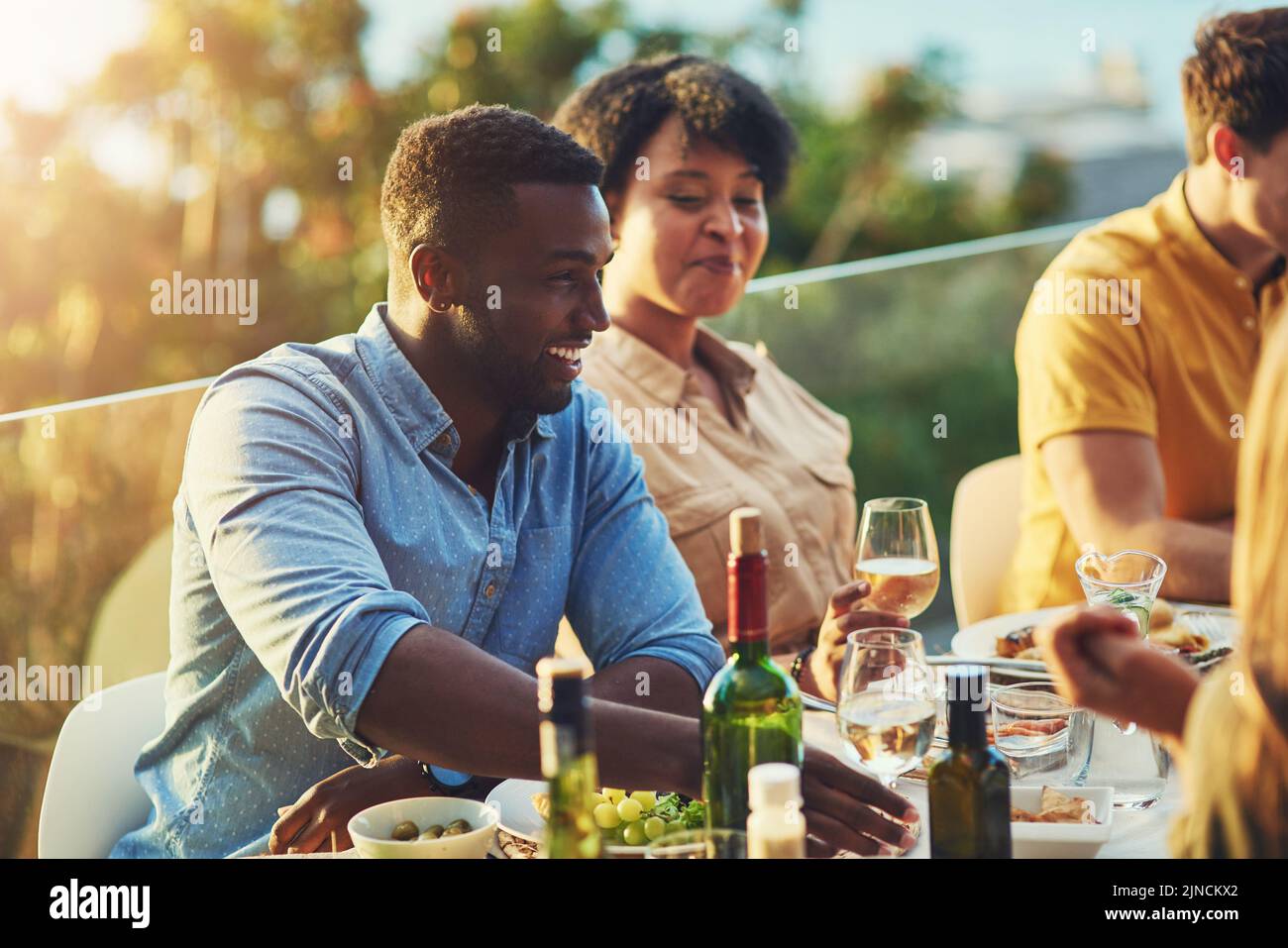 Hes having a great time with his friends. cheerful young man sitting ...