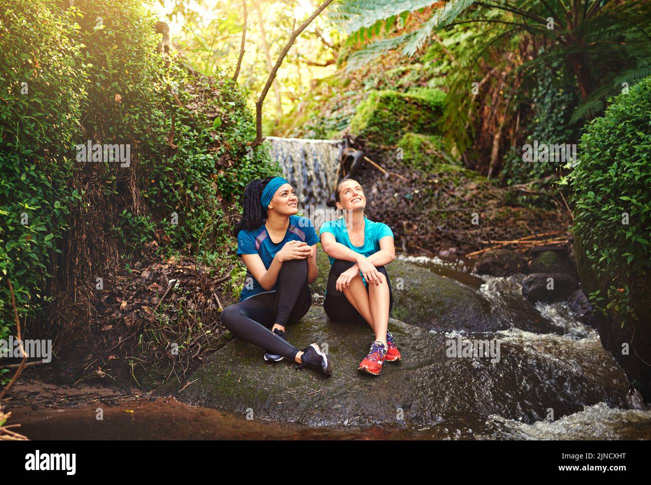 We love being outdoors. two sporty young women taking a break while out ...