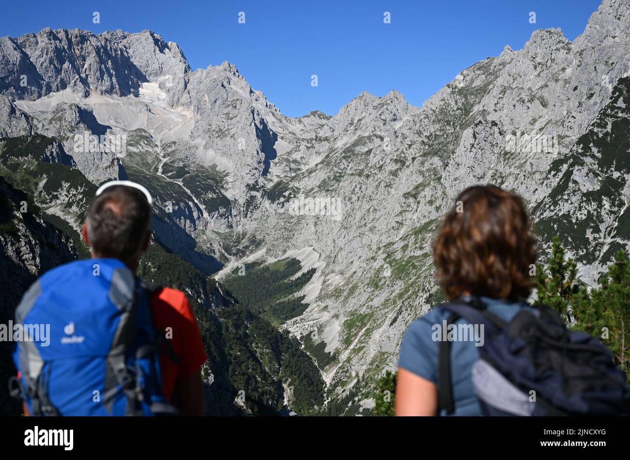 Grainau, Germany. 10th Aug, 2022. Hikers look at the blank ice and the ...