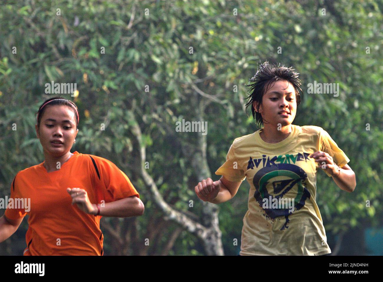 Young women badminton players are running circle a park during a ...