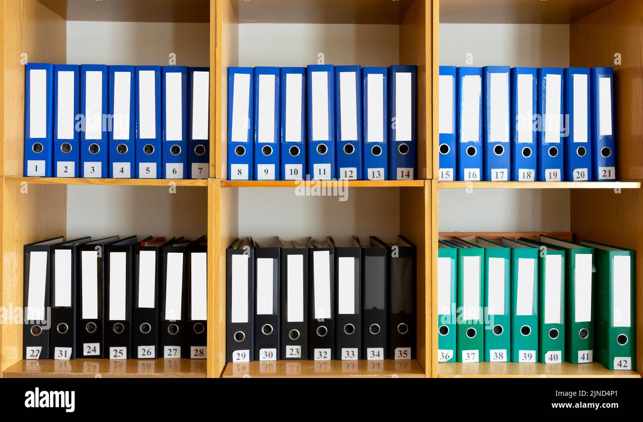 A bookshelf with many different folders on it. There are many different ...