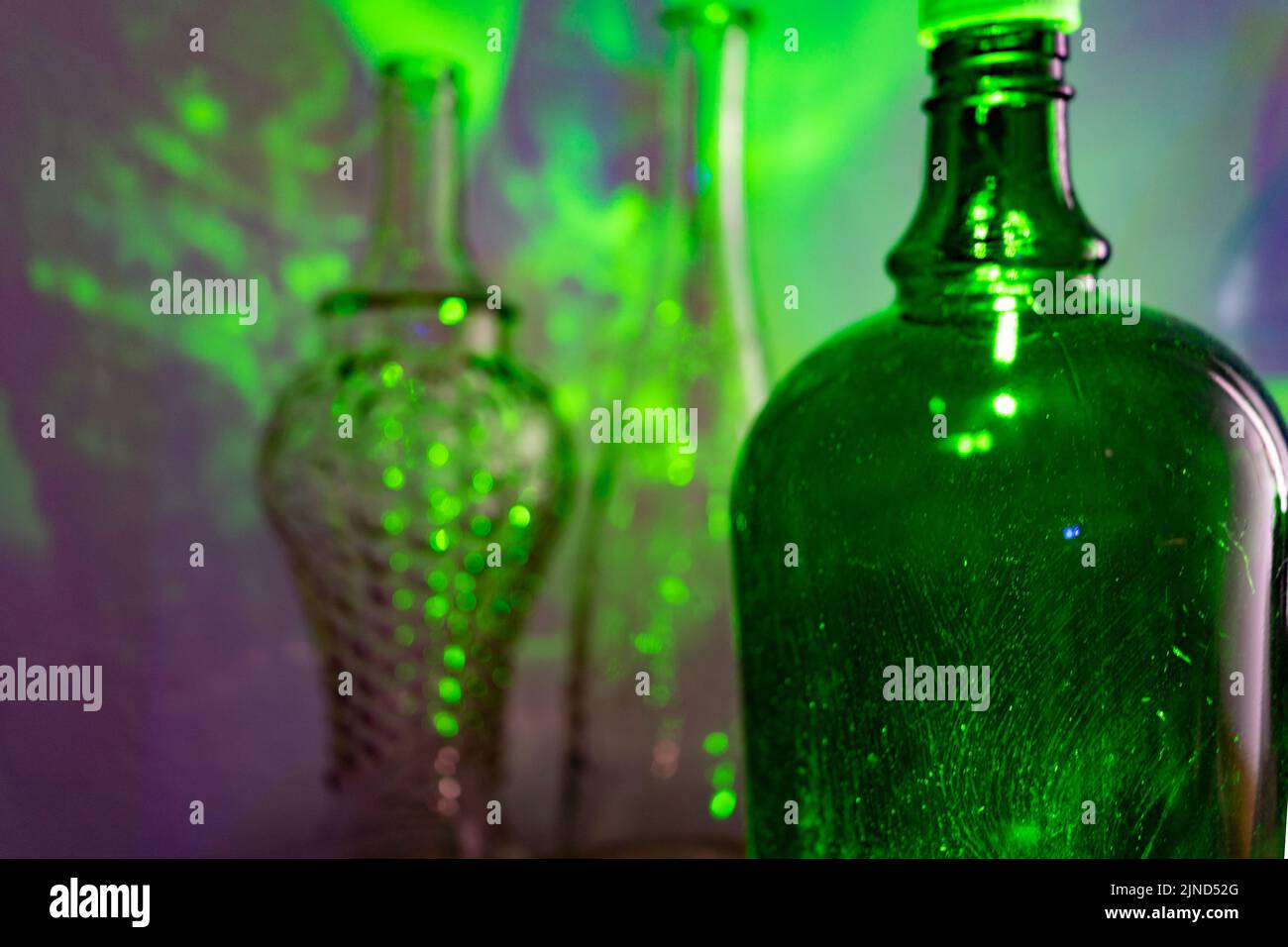 Abstract image of shaped glass bottles with a bright reflection on the ...