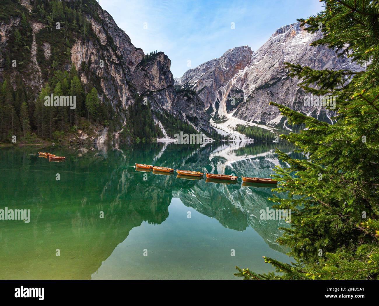 Mount Seekofel and boats in the evening light, mirroring in the clear ...