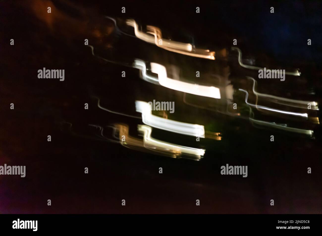 Close up shot of Several different colored lines moving in the dark ...