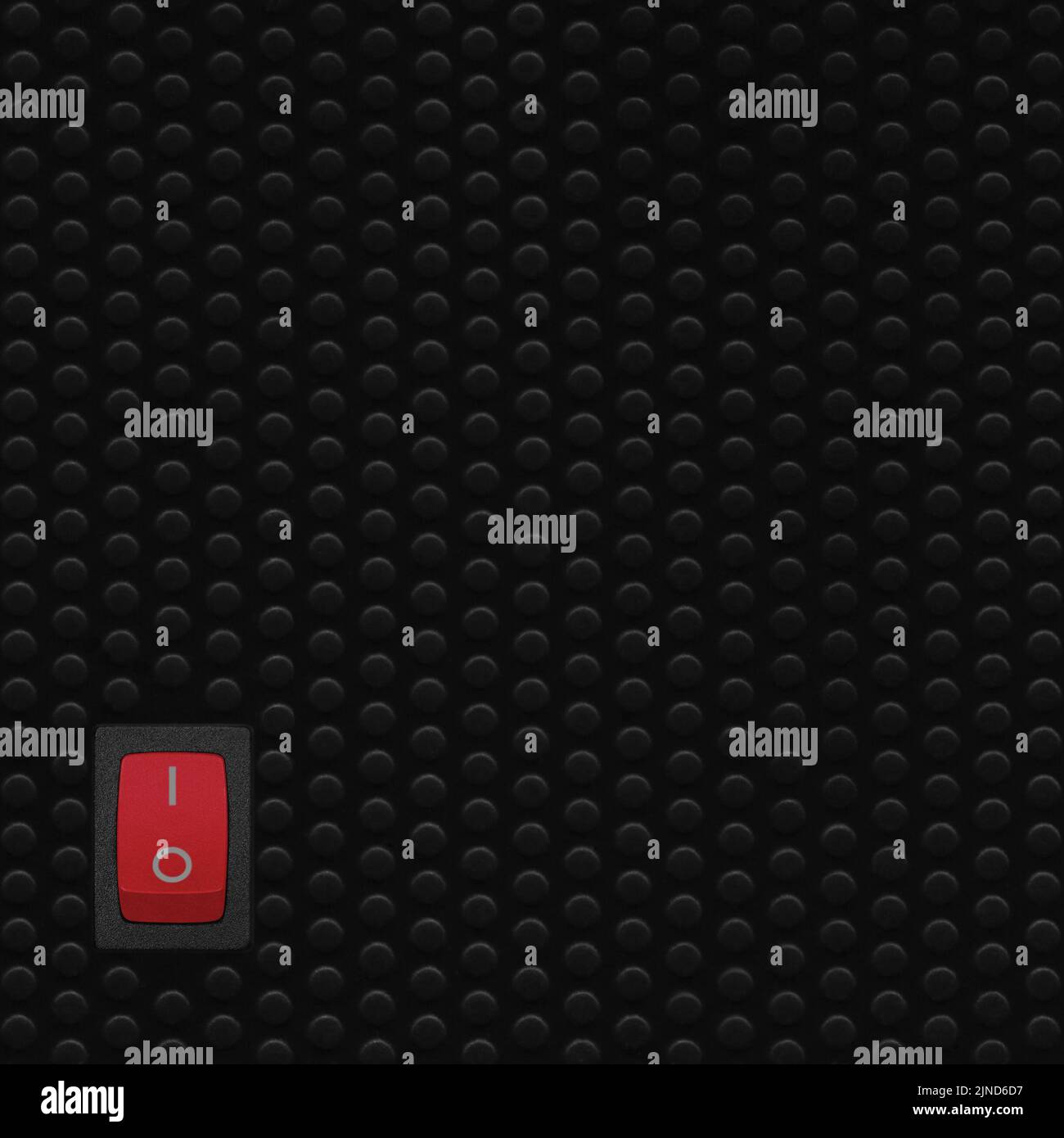 Red rectangle rocker power switch in on position, black abstract dot ...