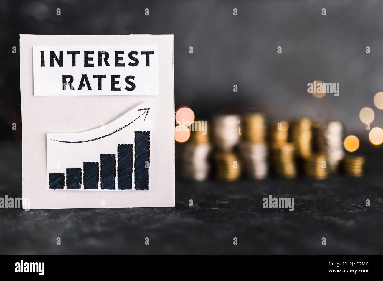 interest rates text and graph showing stats going up in front of stacks ...