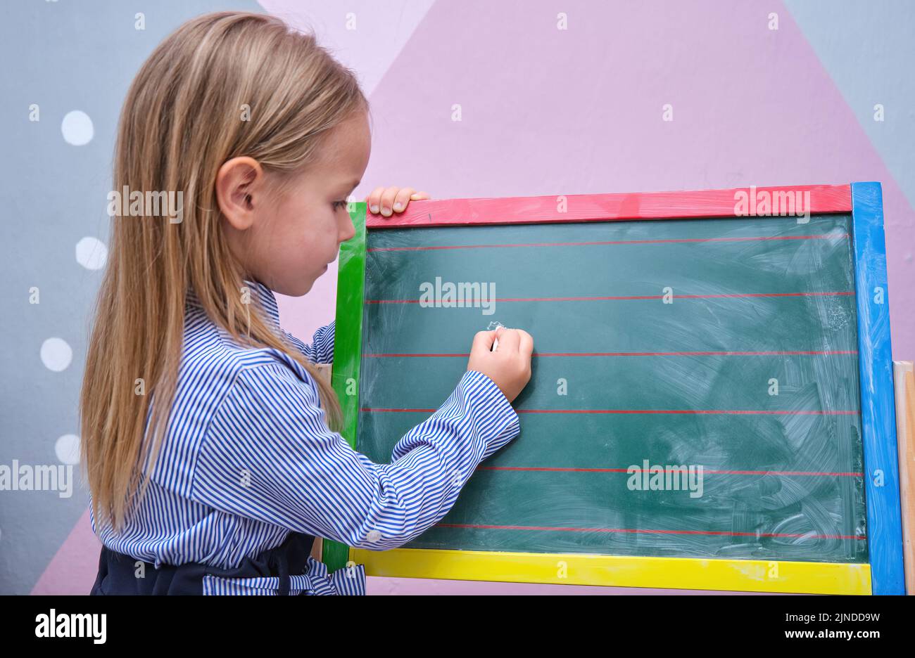 Cute happy pre school little girl write with chalk on blackboard ...
