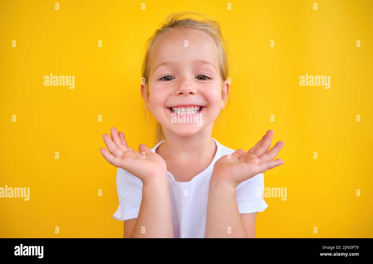 Happy joyful preschool girl smiling hand isolated on yellow background ... Happy joyful preschool girl smiling hand isolated on yellow background ...