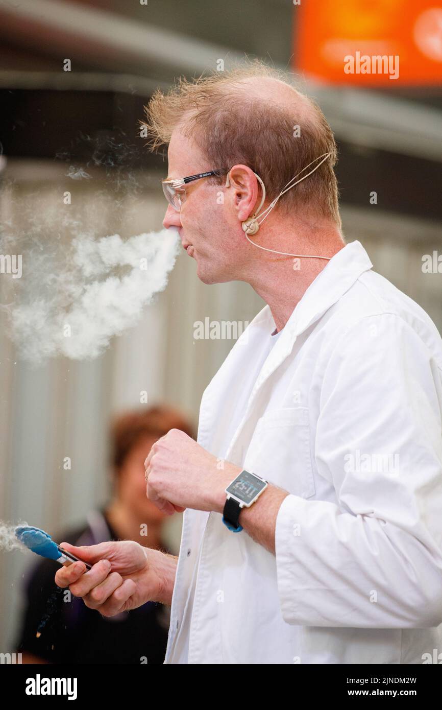 Dr Rob Bell blows out a cloud of vapor after eating food dipped in ...