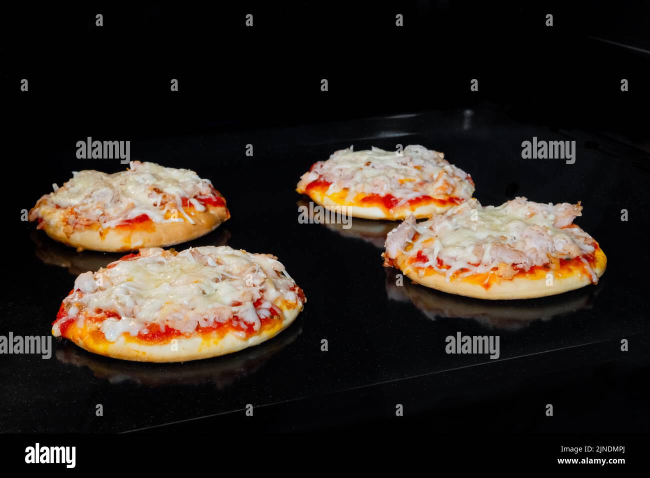 Four baked homemade mini pizzas in electric oven at home Stock Photo ...