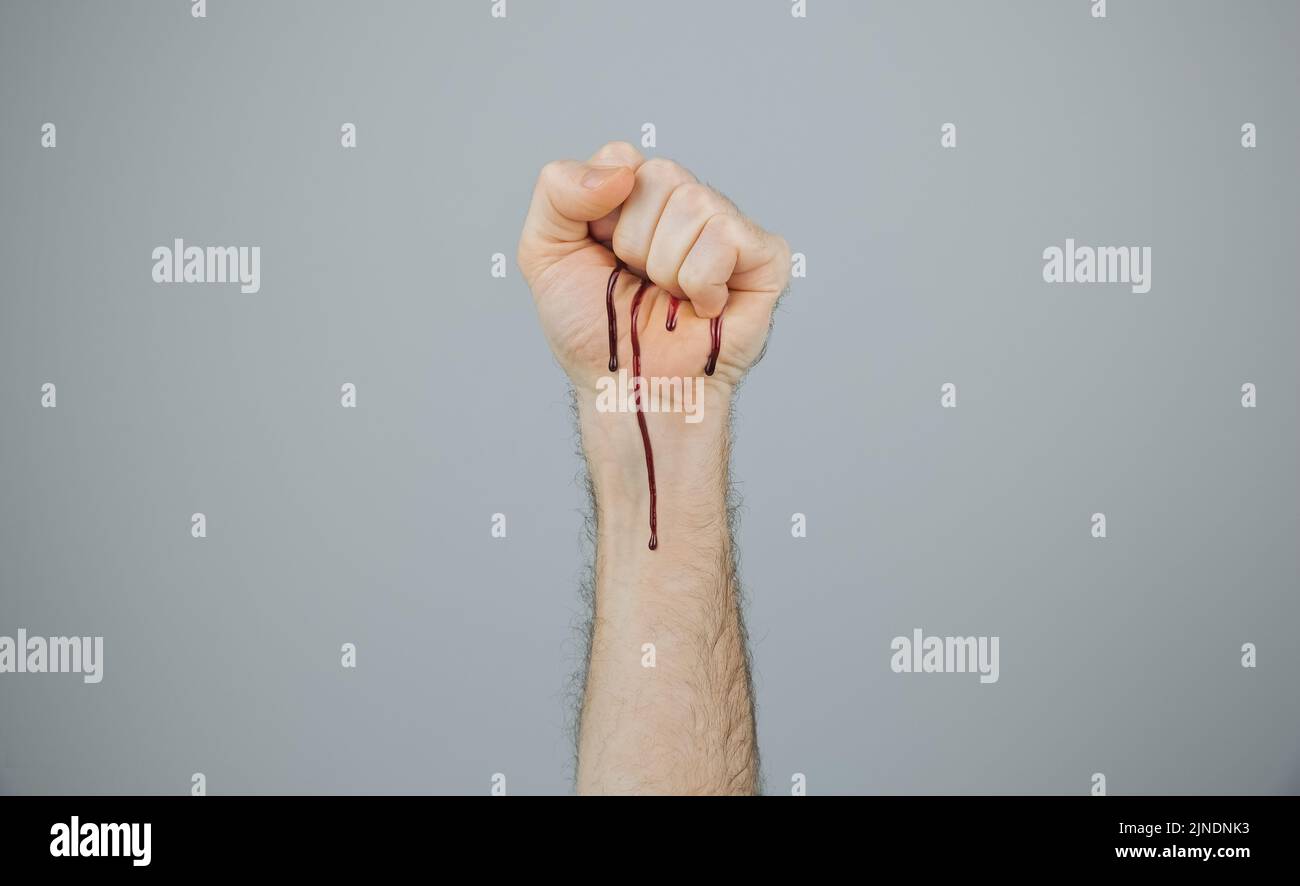 Bleeding clenched fist over gray background Stock Photo - Alamy