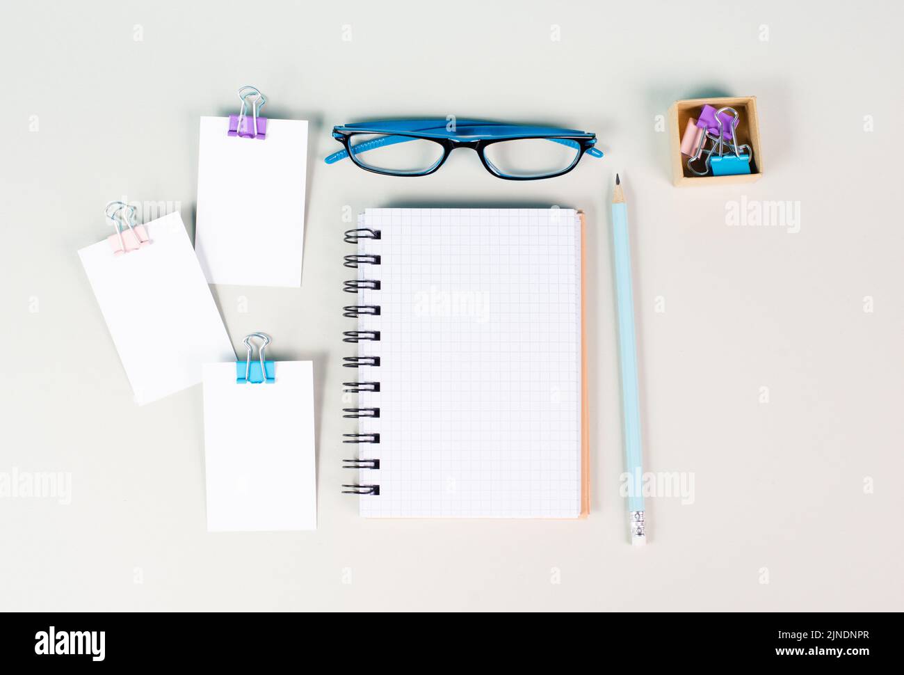 Blank notebook with a pen, paper and eyeglasses on a gray background ...