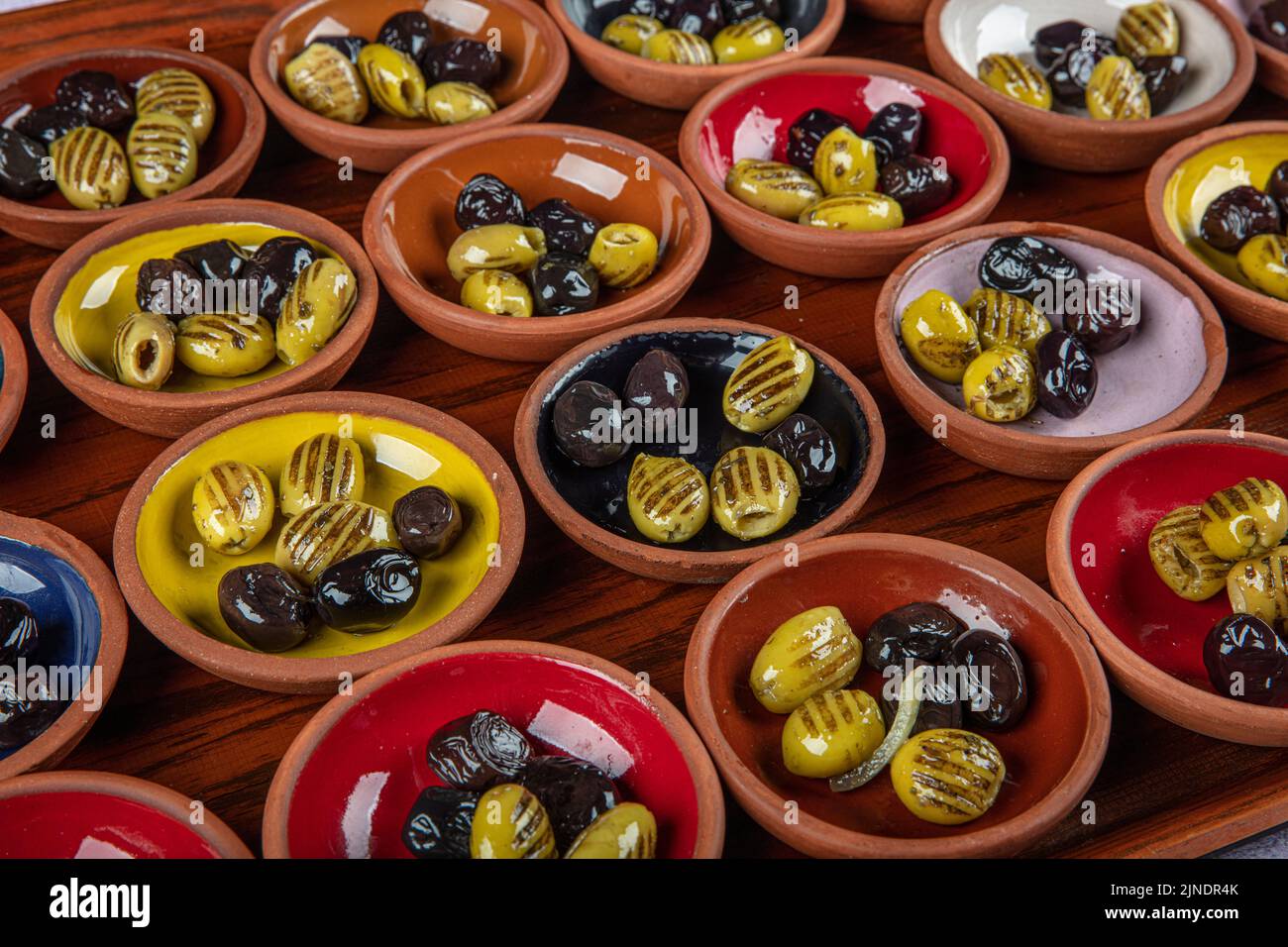 Black and green olives in ceramic bowls on a tray. Olive appetizers on ...