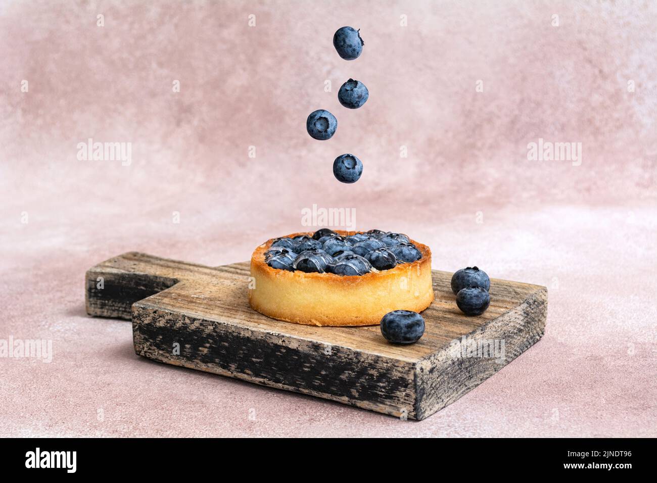 Surreal design with floating berry. Blueberry pie on a wooden board ...