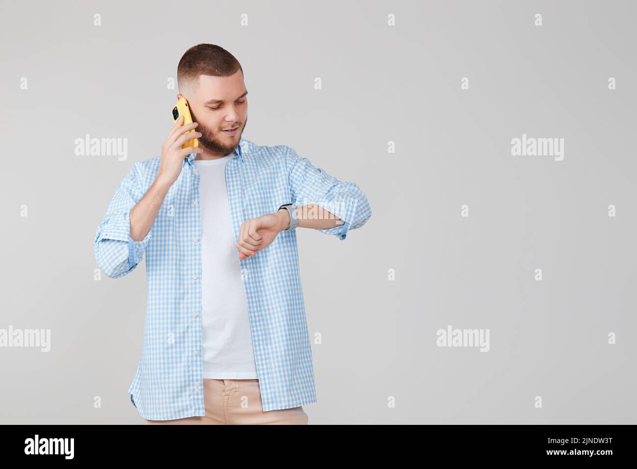 Handsome young man using cell phone while standing Stock Photo - Alamy