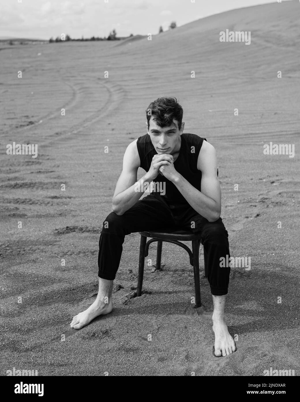 Lone Man sitting on chair in desert Stock Photo - Alamy