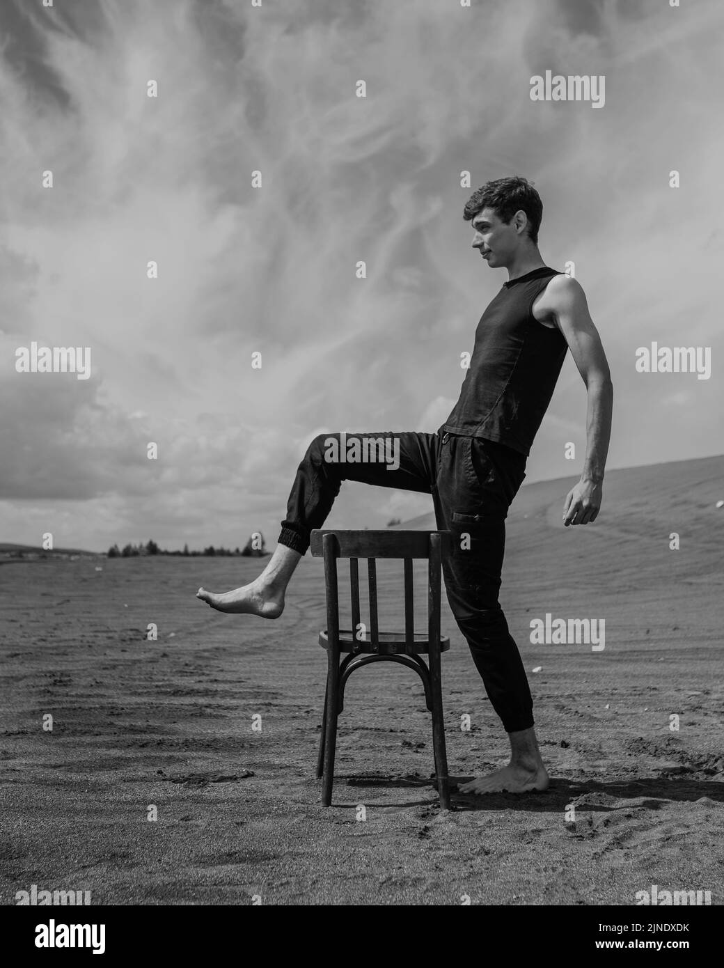 Man jumping over chair in desert Stock Photo - Alamy