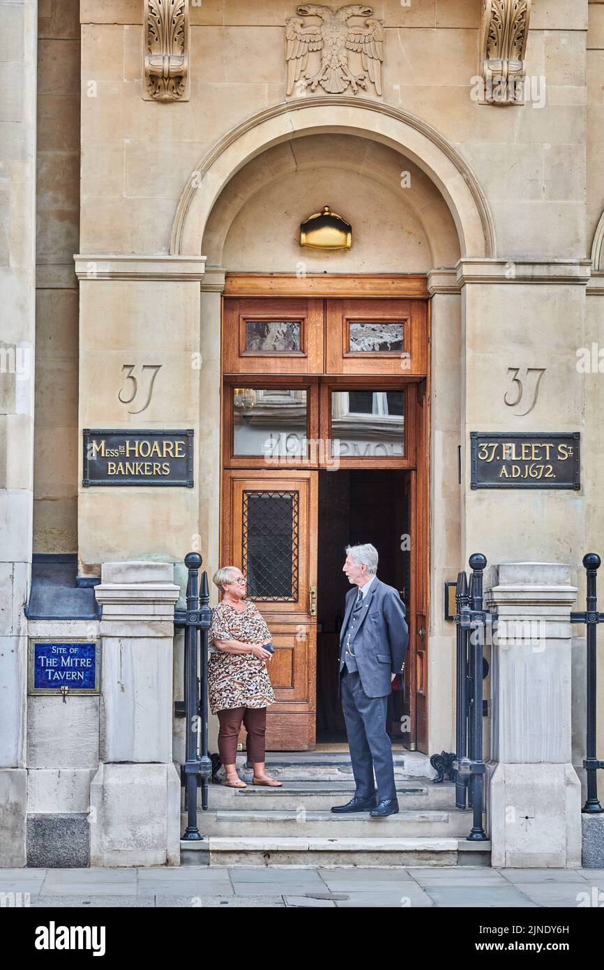 A couple chat on the steps at the building of Messrs C Hoare and ...