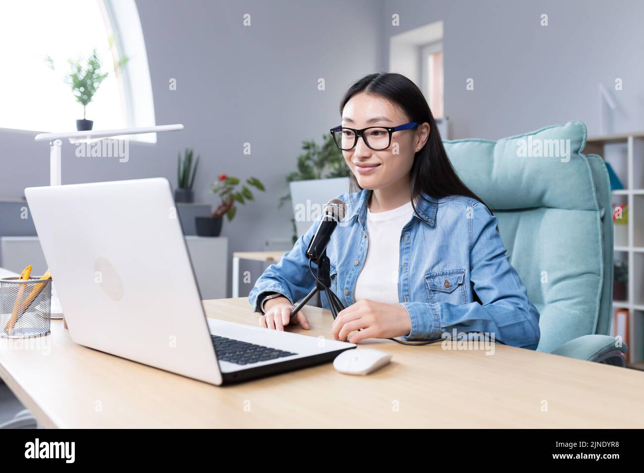 Podcast recording, interview. Young beautiful Asian woman sitting at a ...