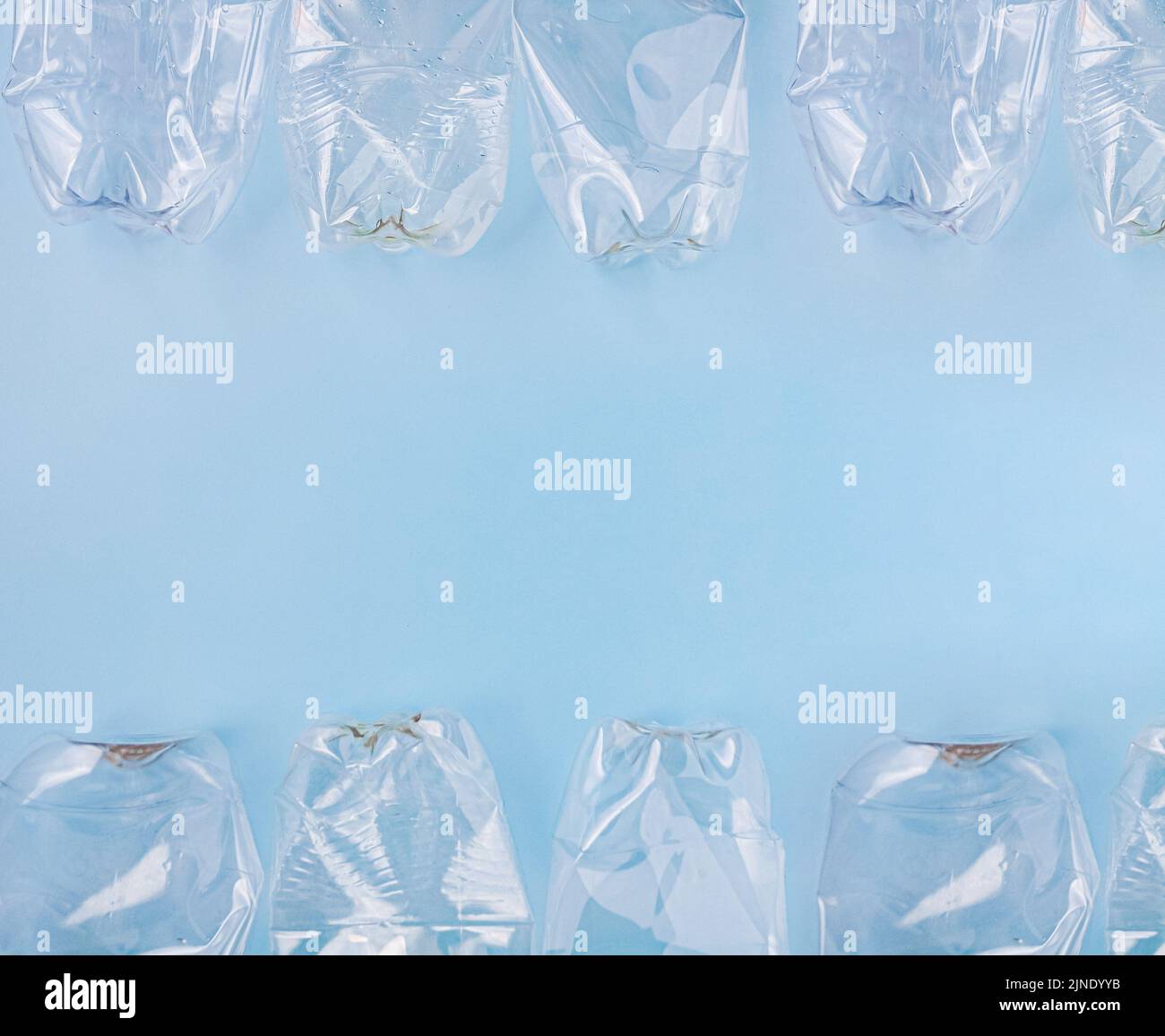 Empty rumpled used plastic bottle on blue background. Top view, copy ...