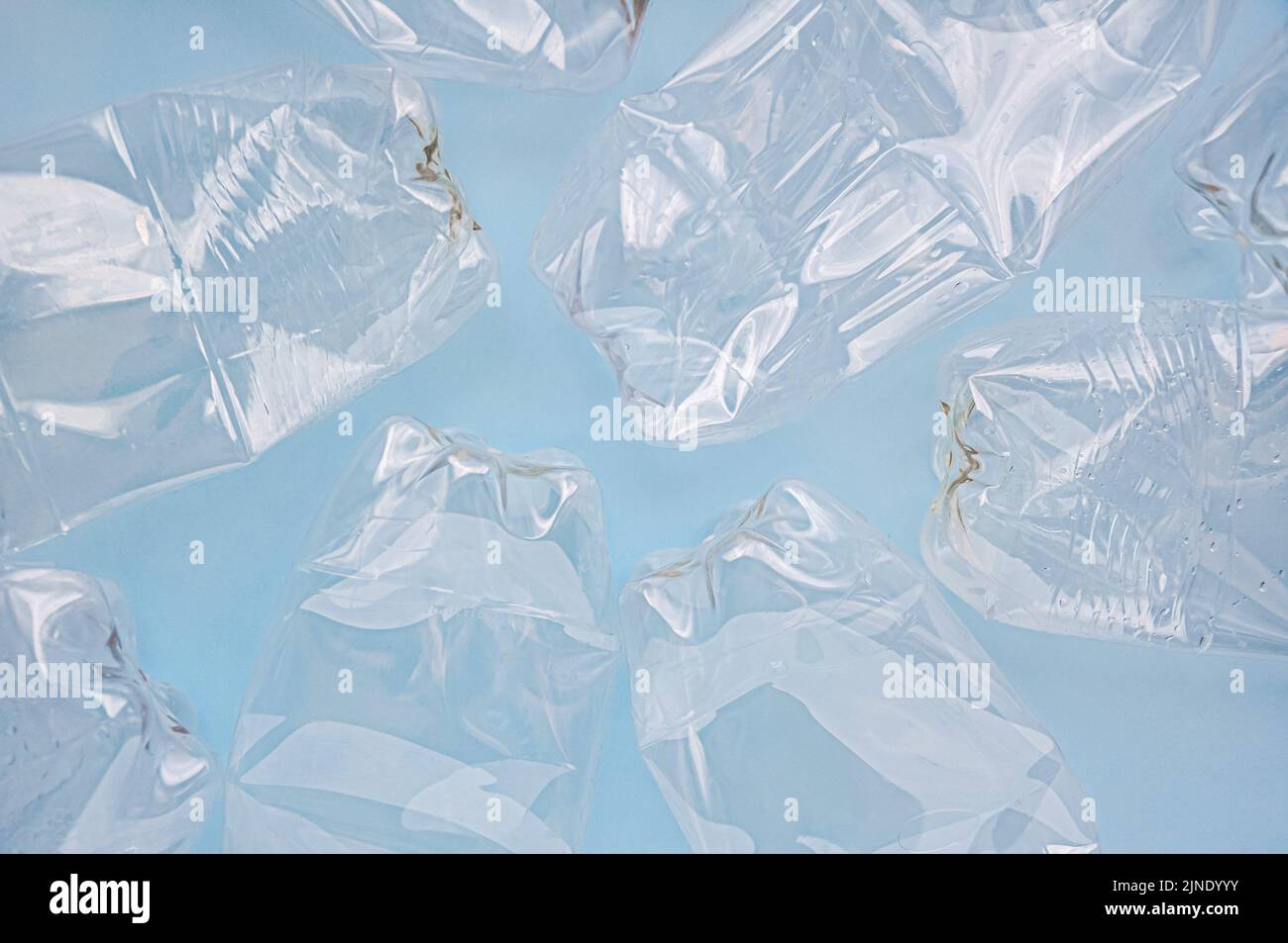 Empty rumpled used plastic bottle on blue background. Top view, copy ...