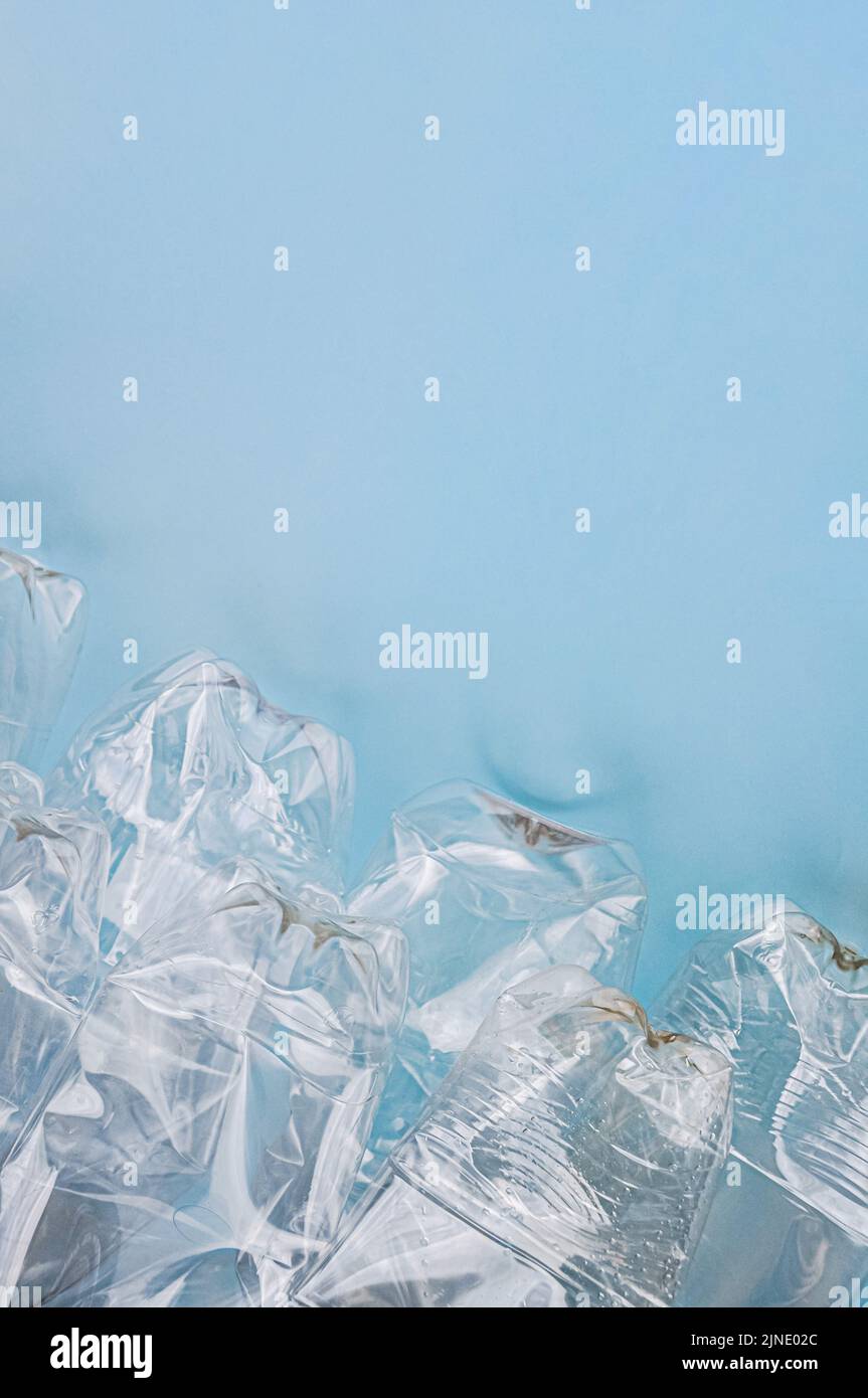 Empty rumpled used plastic bottle on blue background. Top view, copy ...