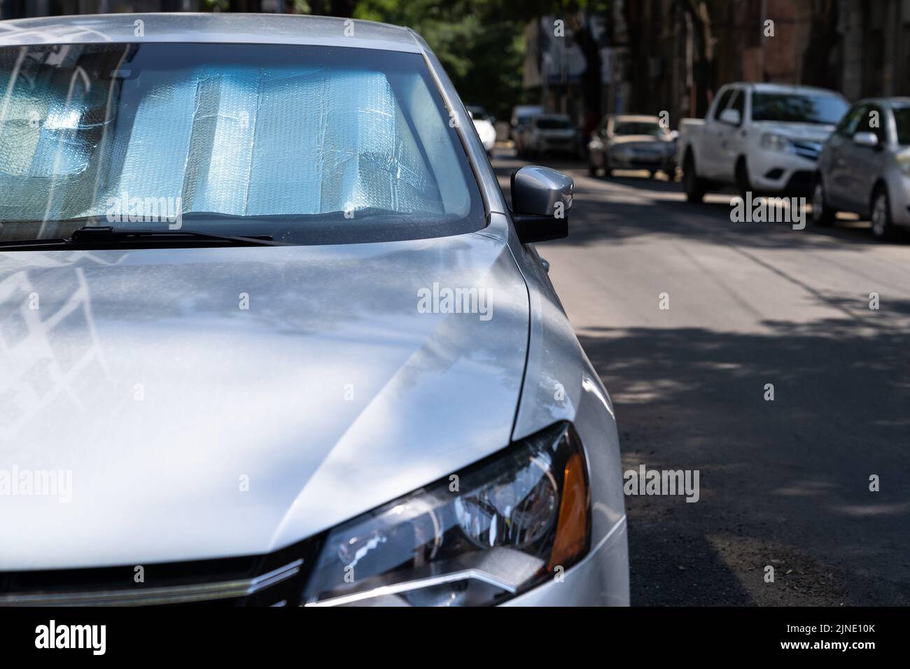 Protective reflective surface under windshield of car on hot day ...