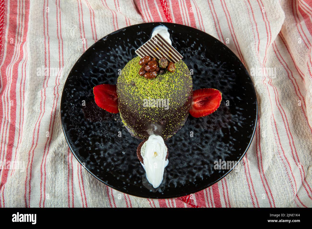 Single sweet cake. Glazed chocolate cake, one piece, on black plate ...