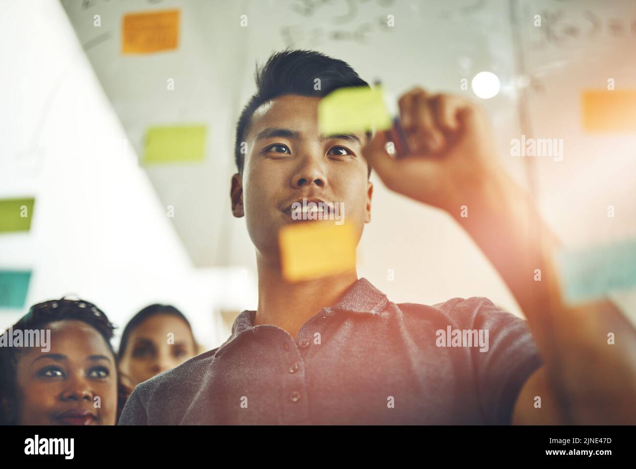 A marketing professional brainstorming ideas with colleagues, writing ...