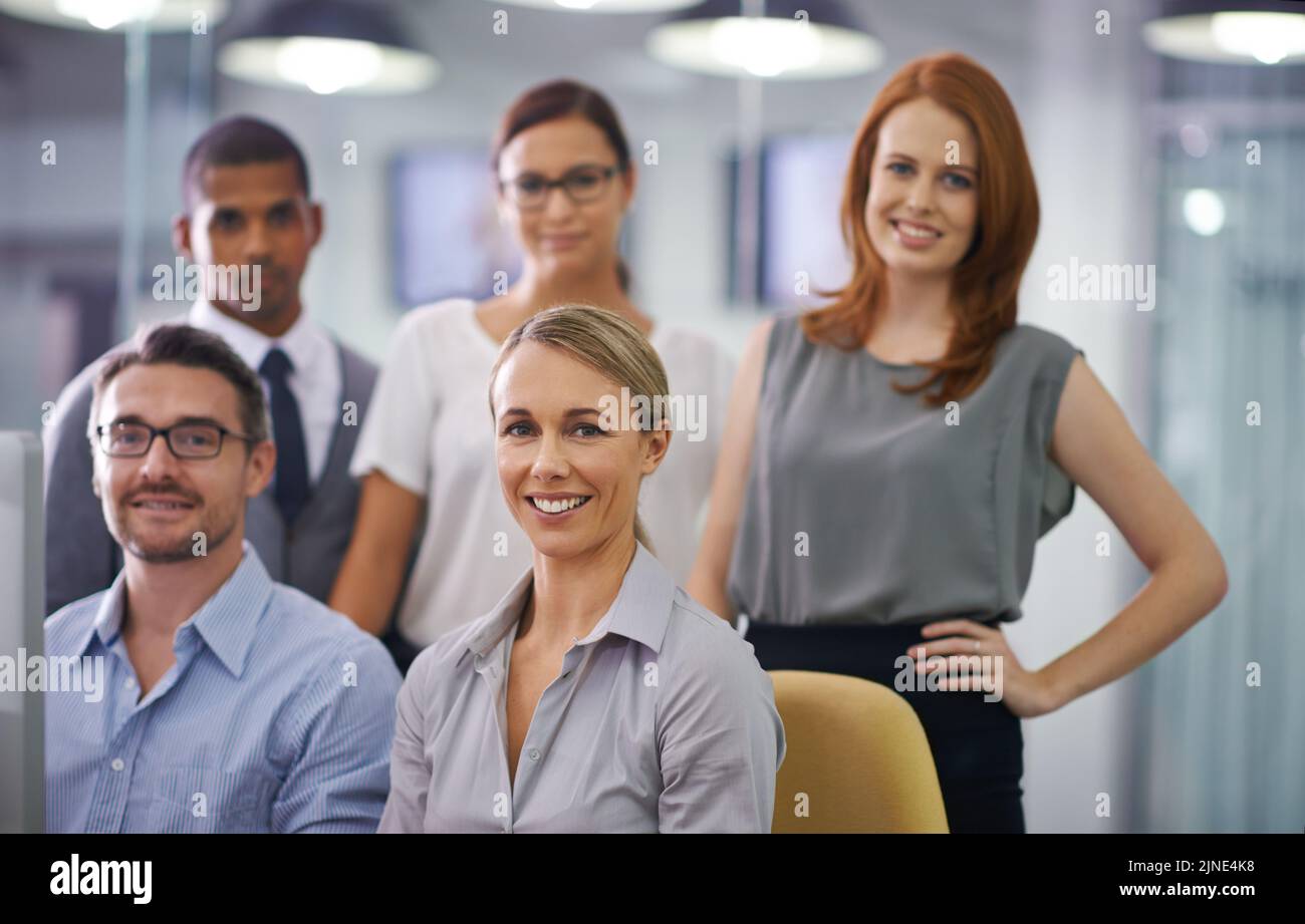 Group portrait of smiling businesspeople with computer working together ...