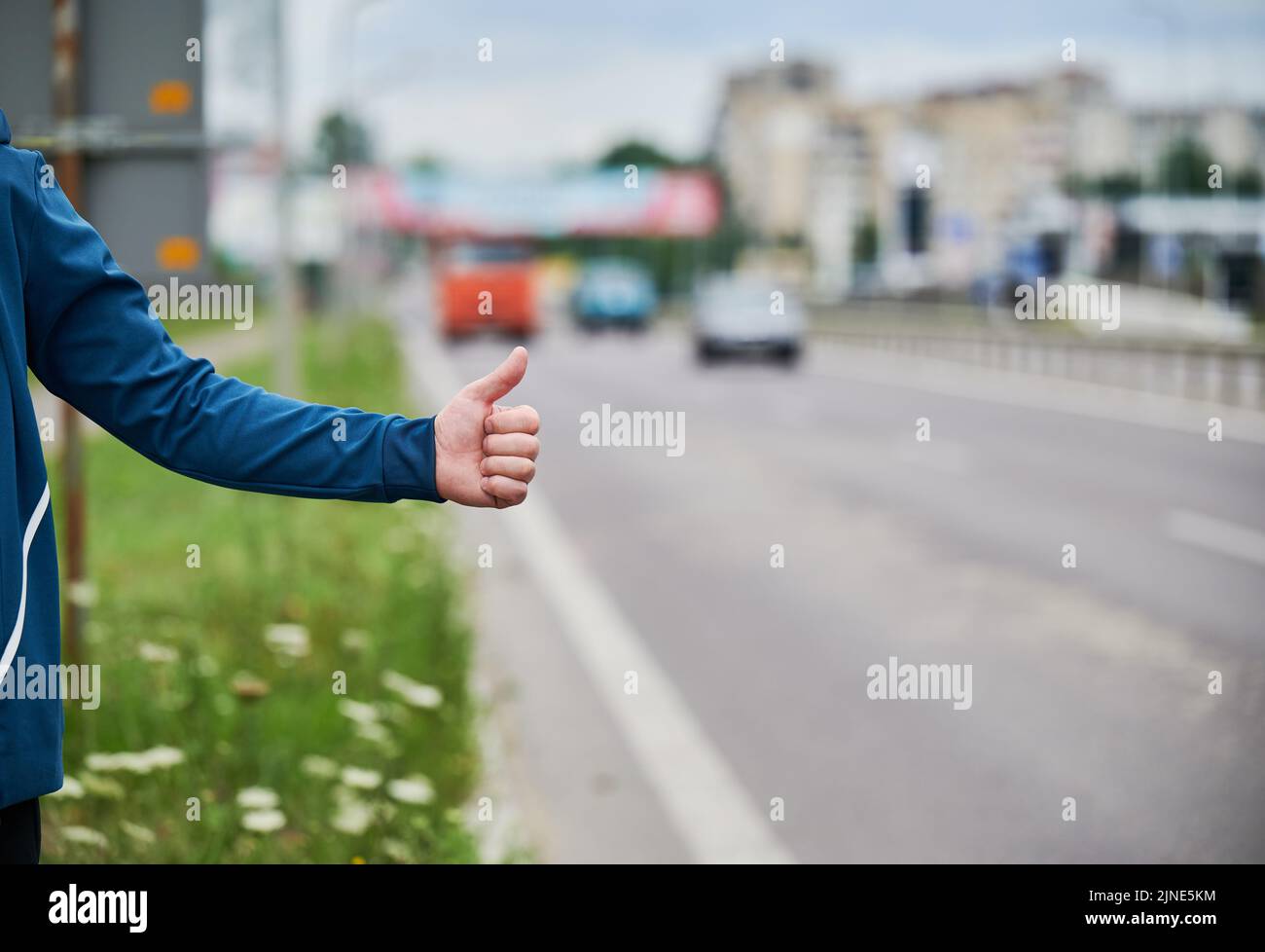 Close up of man's hand hitchhiking by roadside. Male hand showing ...