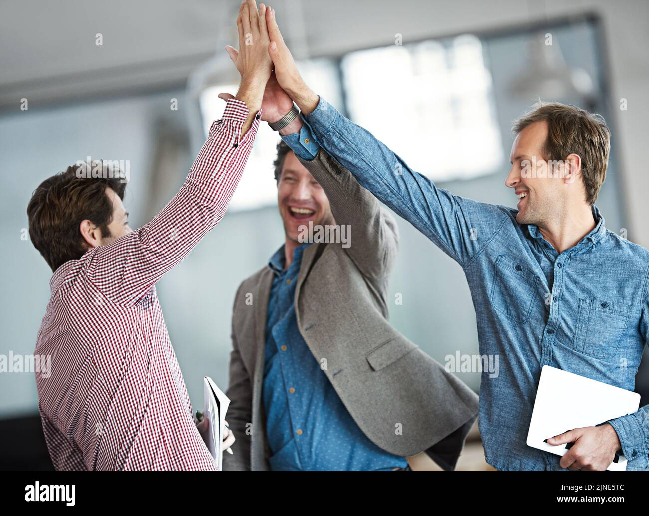 Excited, cheerful and happy group of male business people high fiving ...