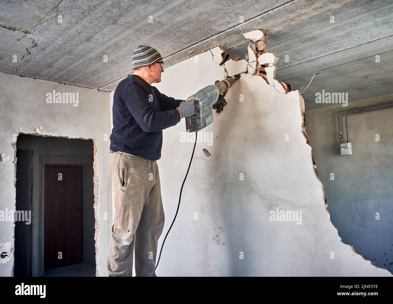Adult skilled wall demolition specialist destroying inner wall by ...