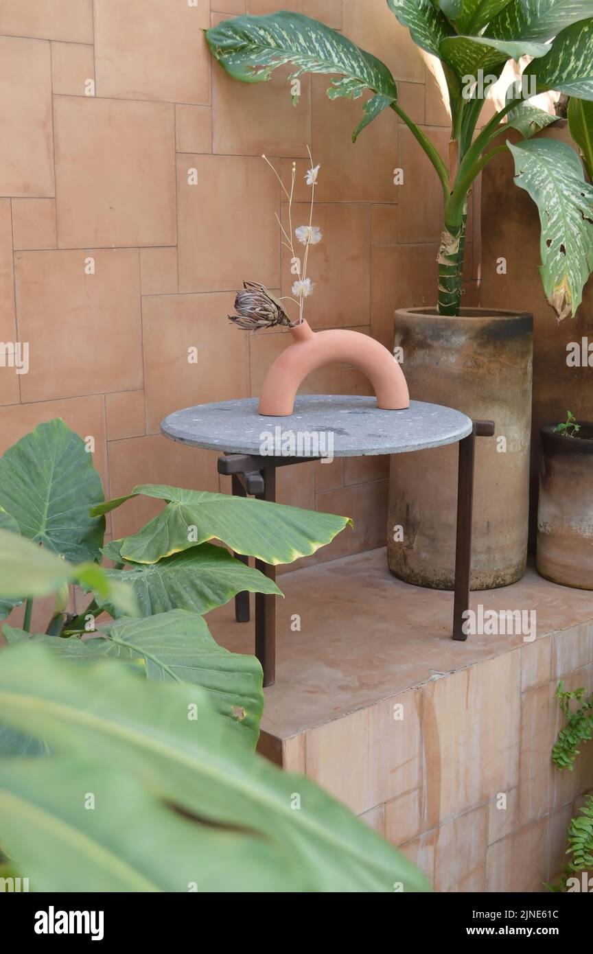 A vertical shot of a modern round coffee table decorated with a clay ...