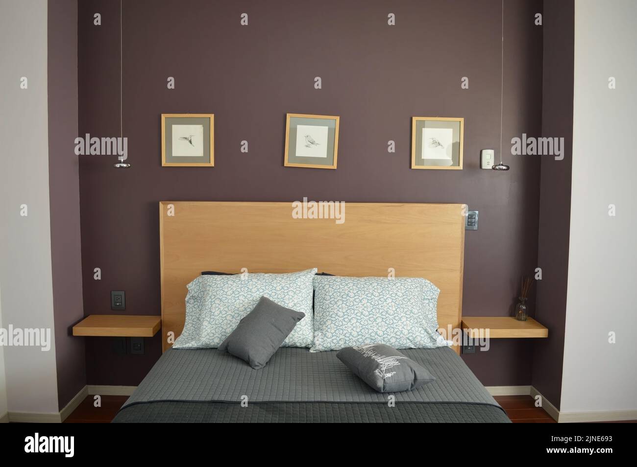A stylish cozy bedroom interior with pictures and hanging lamps Stock ...