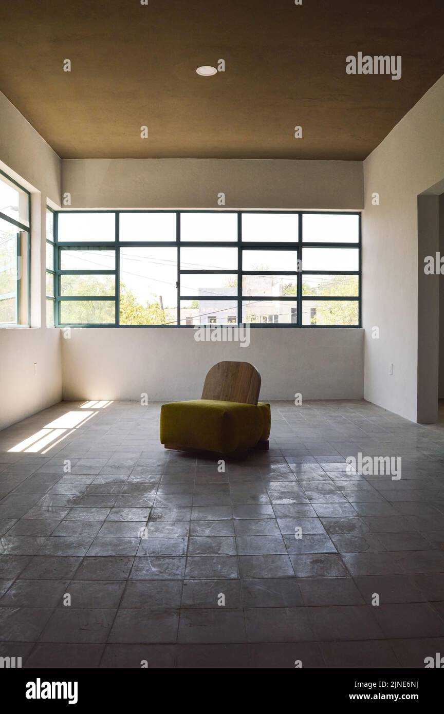 A vertical shot of a modern yellow armchair in an empty room Stock ...