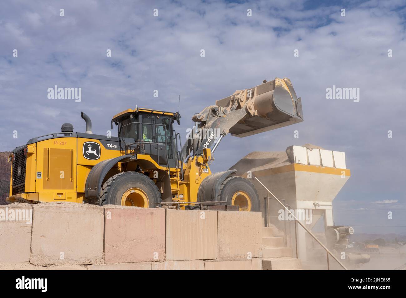 A Deere 744L Wheel Loader dumping aggregate into a hopper for the ...
