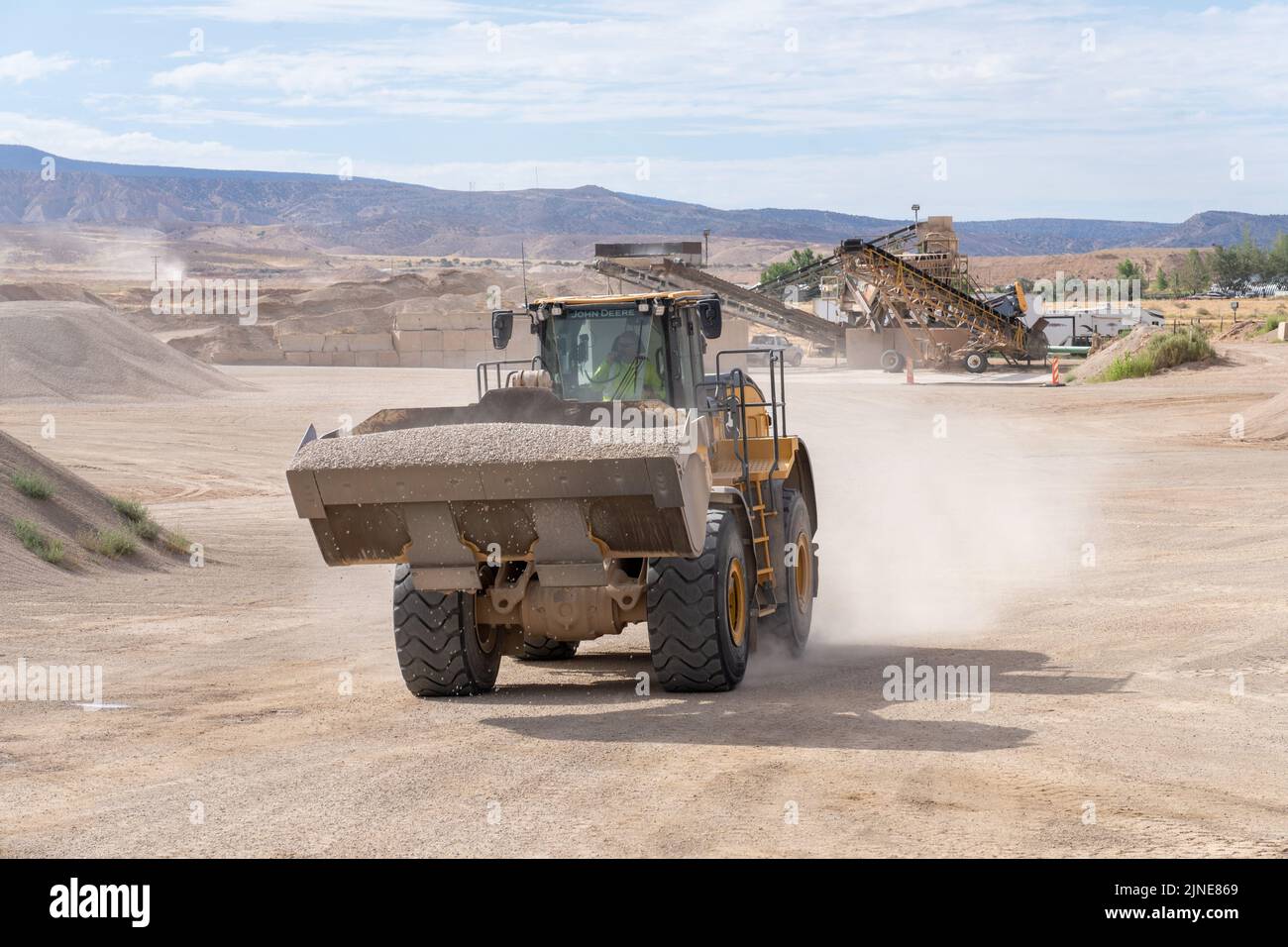A Deere 744L Wheel Loader carrying a load of aggregate for the asphalt ...