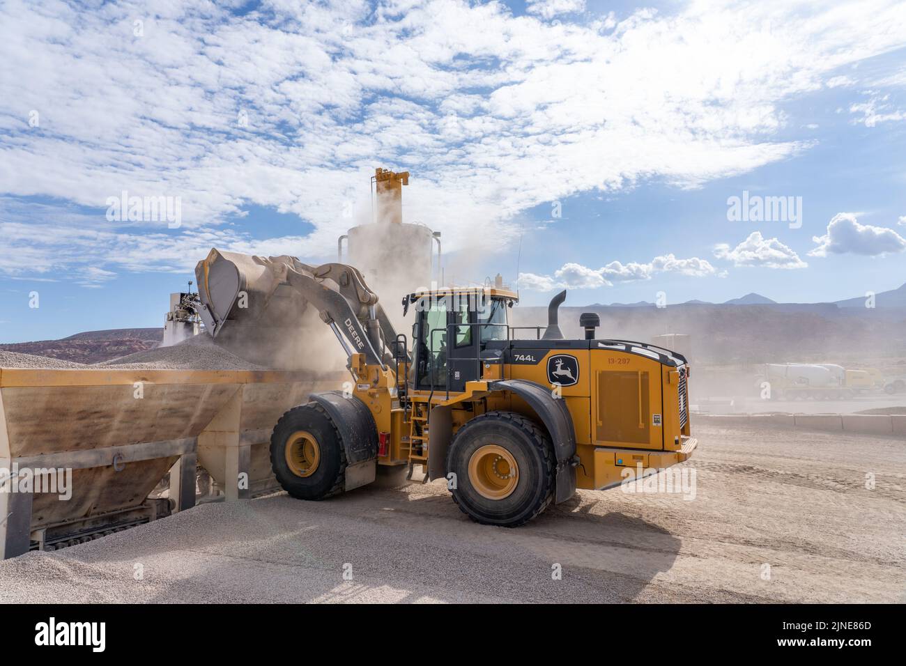 A Deere 744L Wheel Loader dumping aggregate into a hopper for the ...