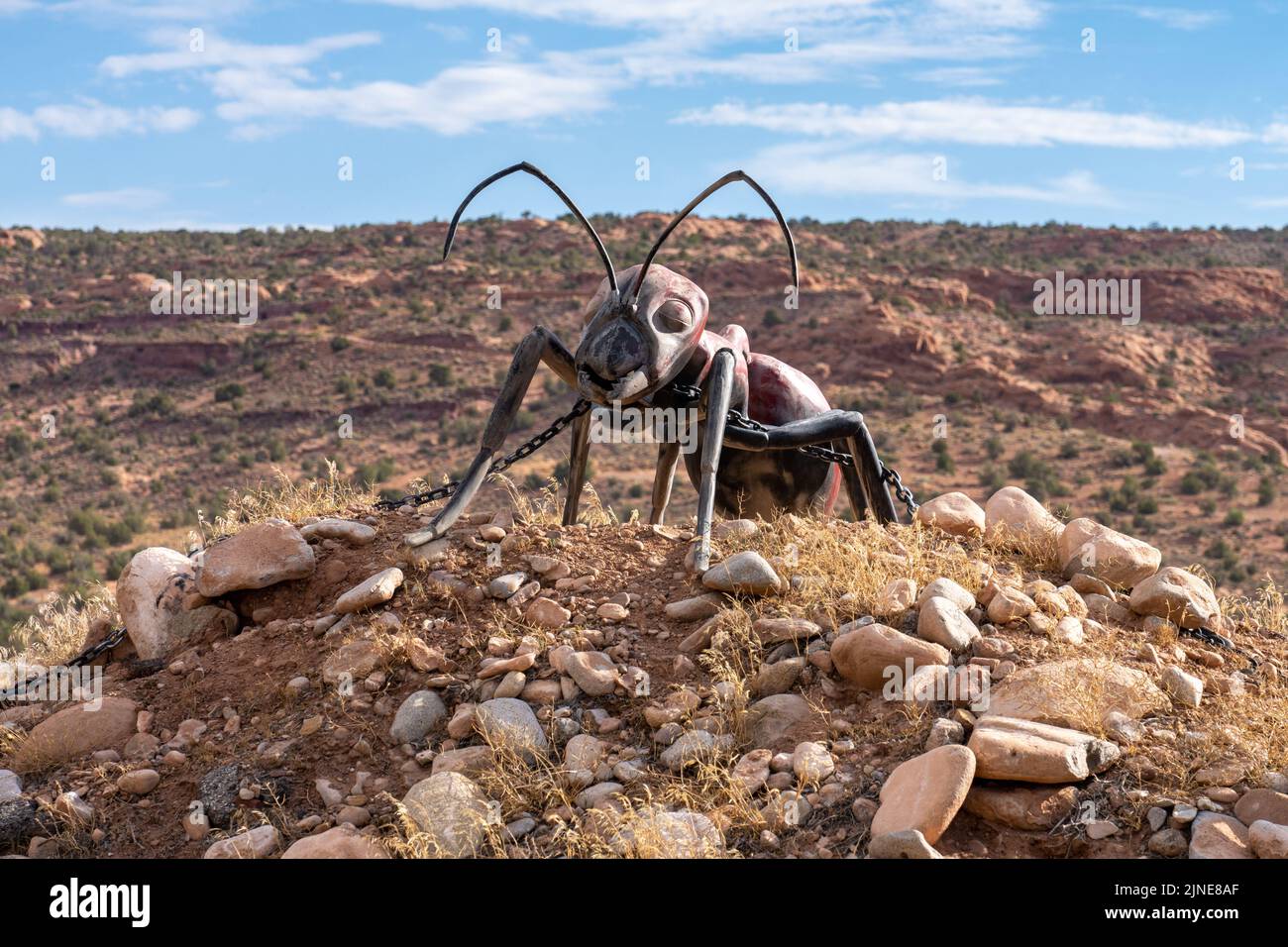 A giant metal ant sculpture, about 6 feet long, on a big anthill near ...