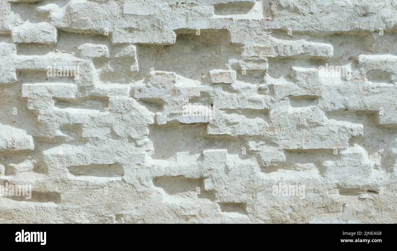 A brick wall painted with white primer is the wall of an old manor ...
