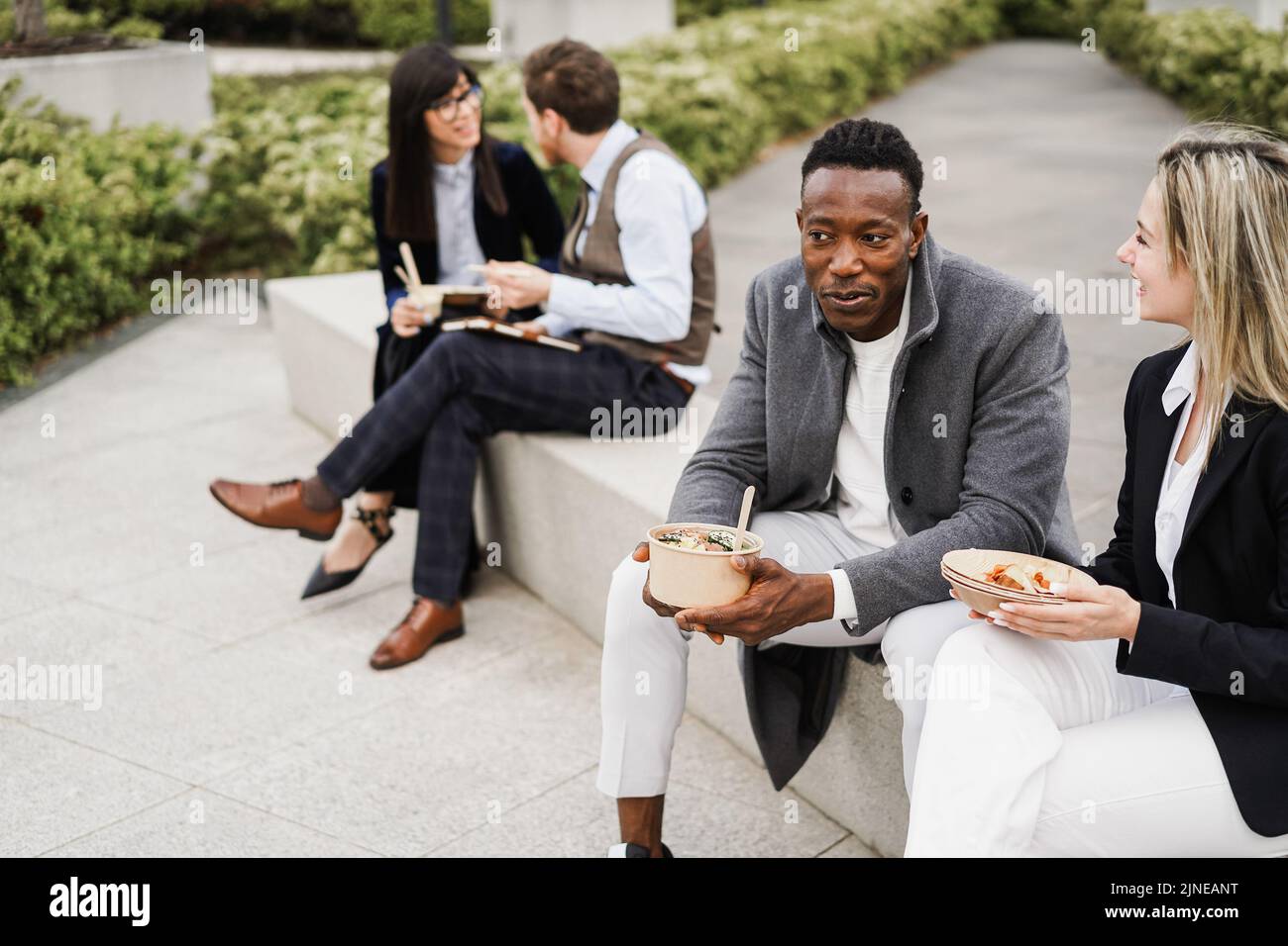 Multiethnic business people doing lunch break outdoor from office ...