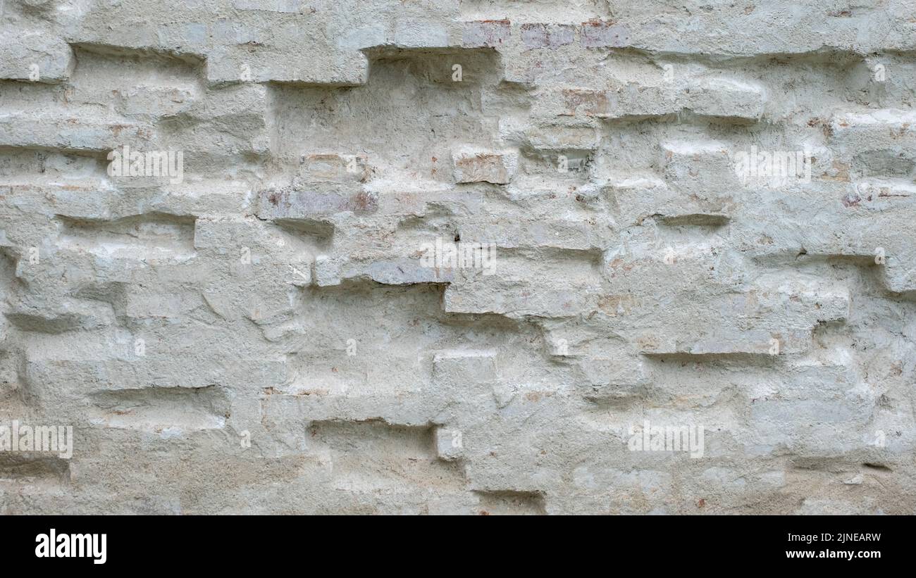 A brick wall painted with white primer is the wall of an old manor ...