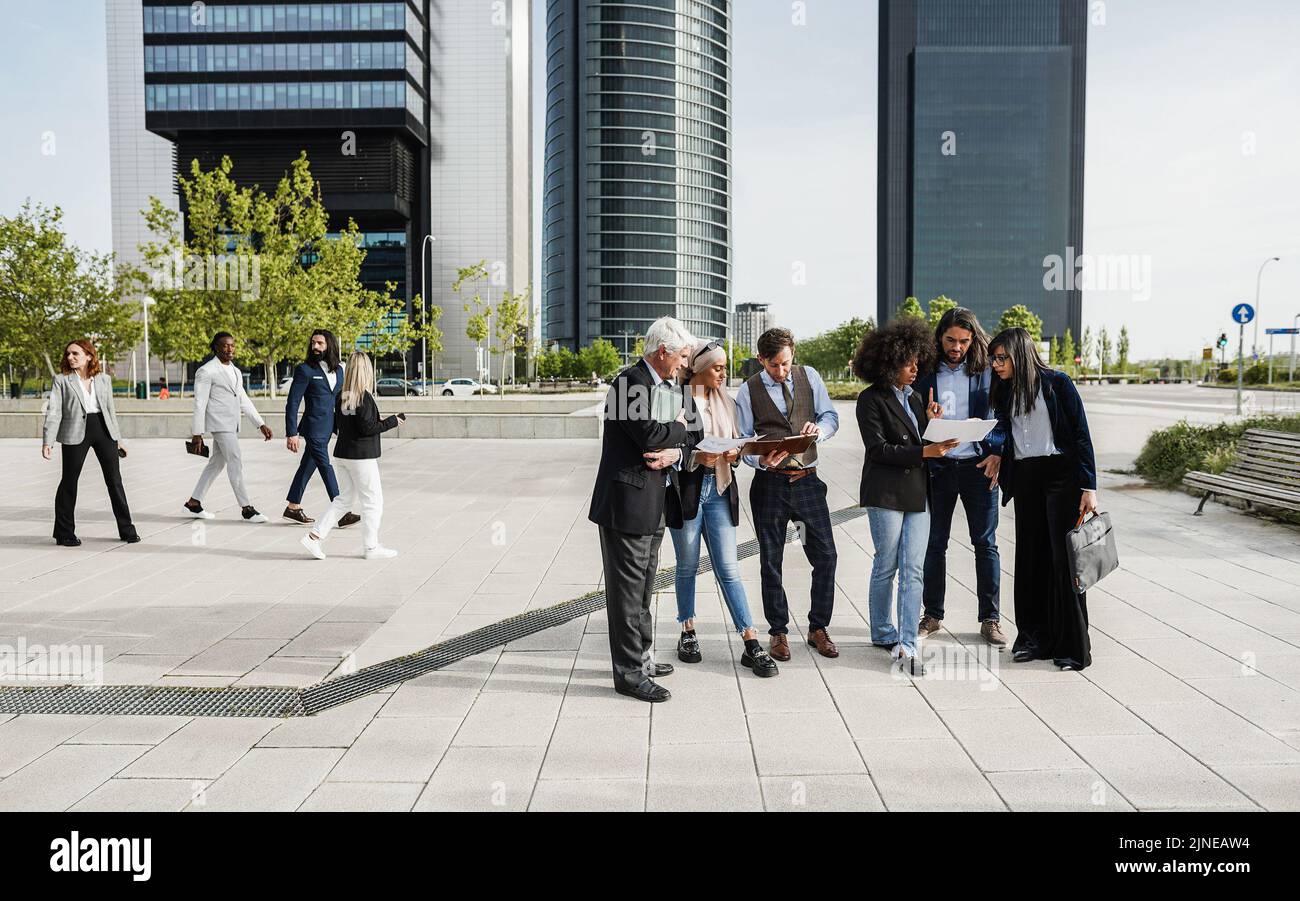Multiethnic business people working outdoor from office building ...