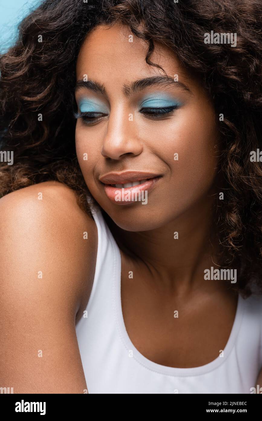 portrait of smiling african american woman with perfect face and blue ...