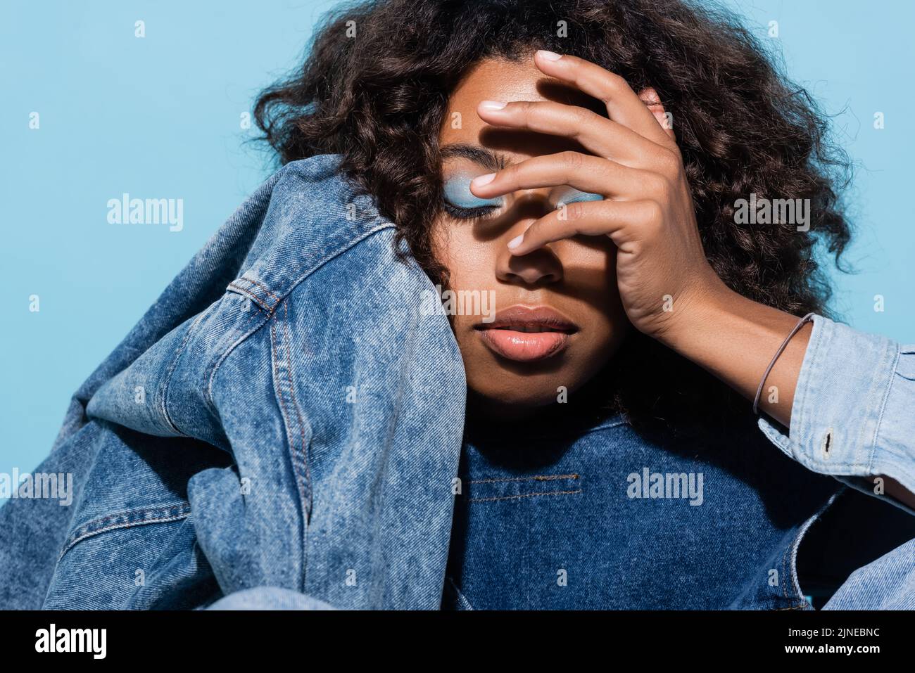 african american woman with closed eyes obscuring face with hand ...