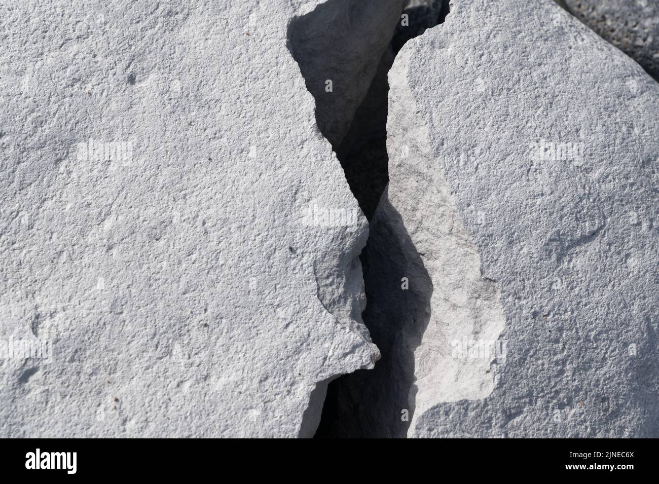 A split rock has a large crack through it which makes it look like a ...